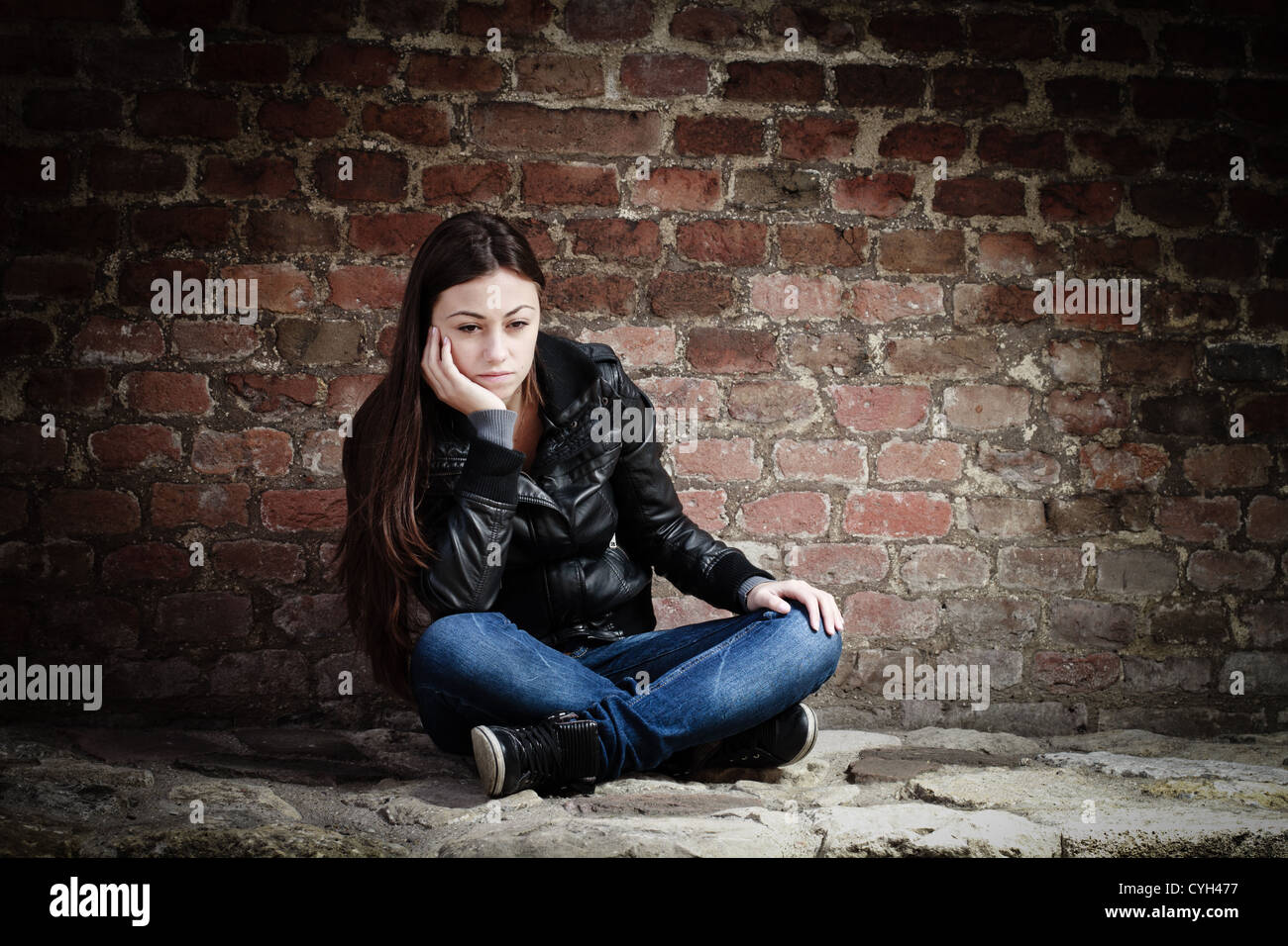 Sad teenage girl, leaning on an old brick wall Stock Photo - Alamy