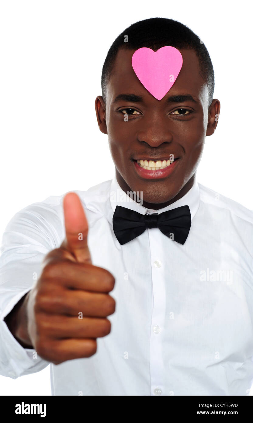 Heart shaped sticky note on african mans forehead gesturing thumbs-up ...