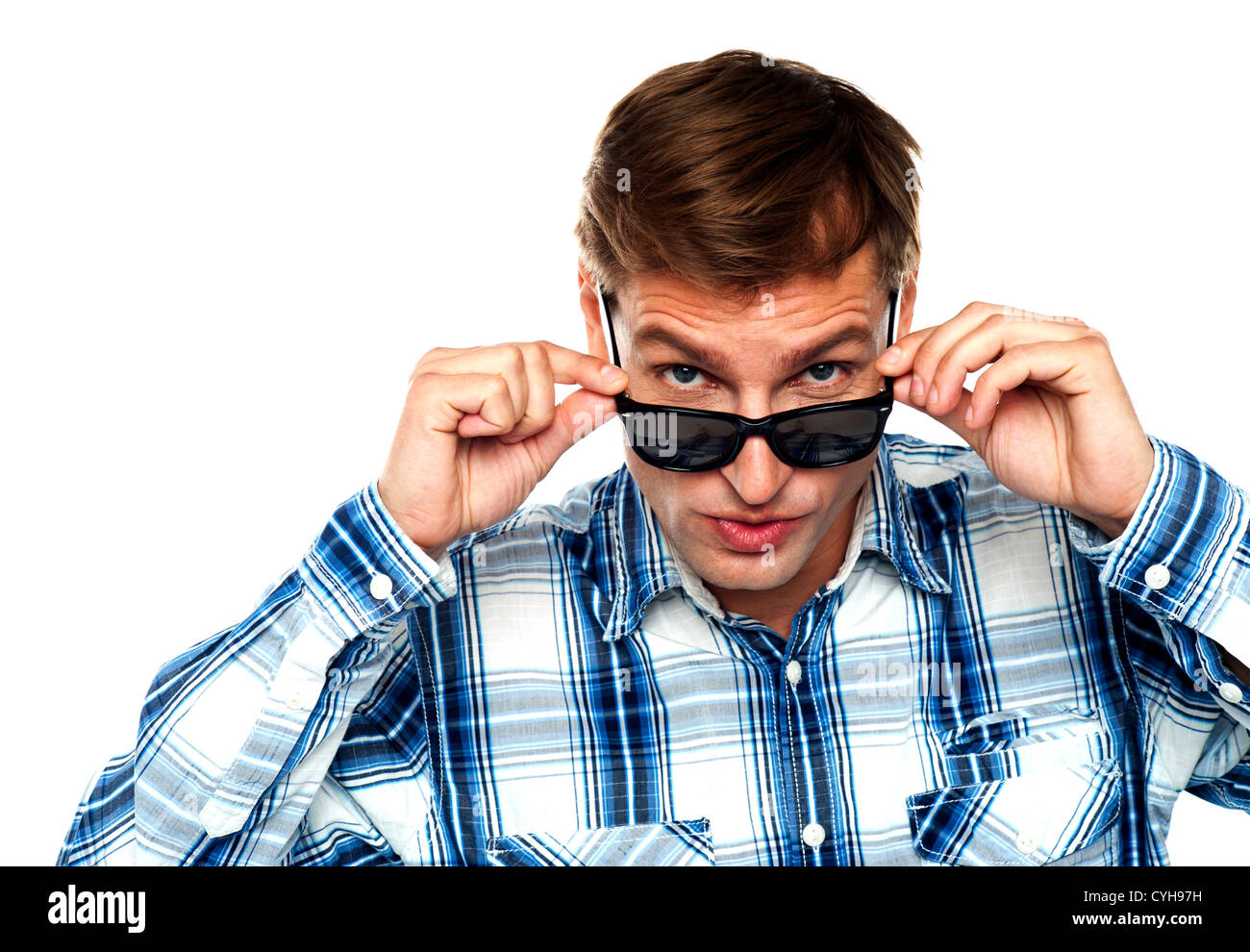 Confident young man peeping from behind the goggles right into camera ...