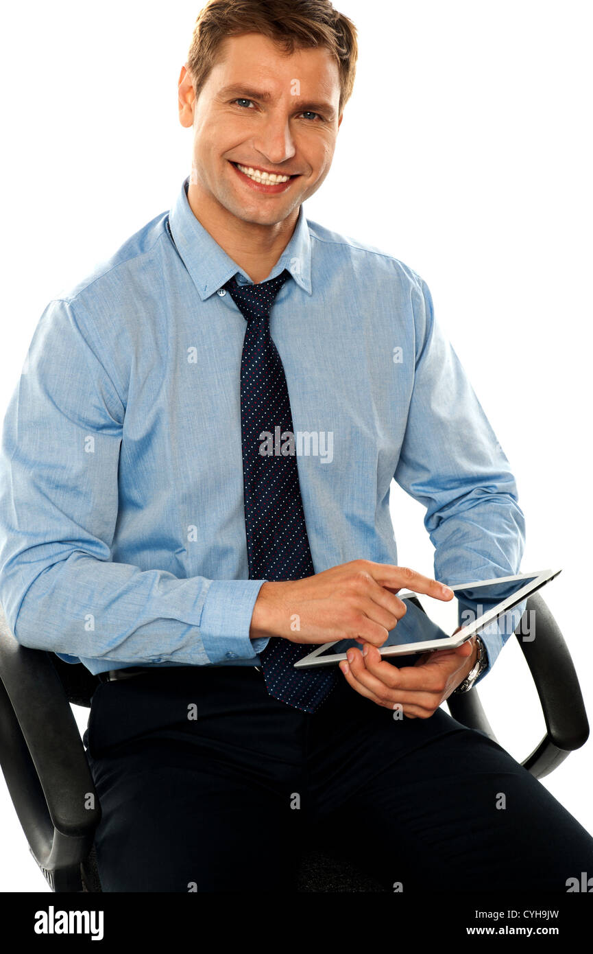 Portrait of relaxed businessman using tablet pc sitting on chair Stock ...
