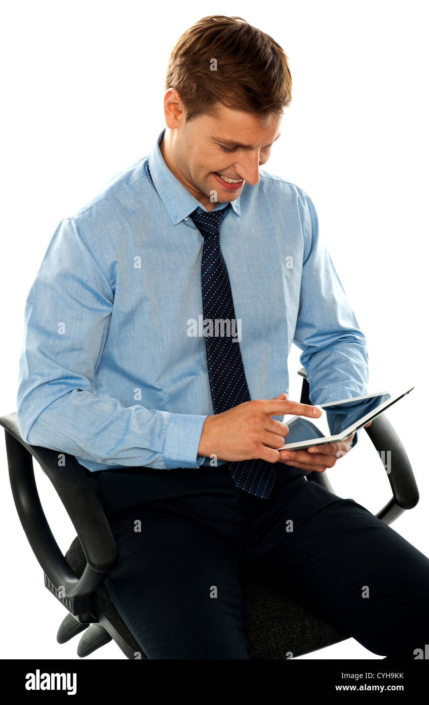 Businessman watching videos on his new tablet pc. Sitting on chair ...