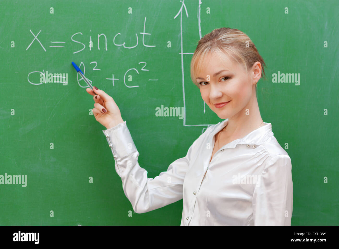 The teacher in the classroom on blackboard background Stock Photo - Alamy