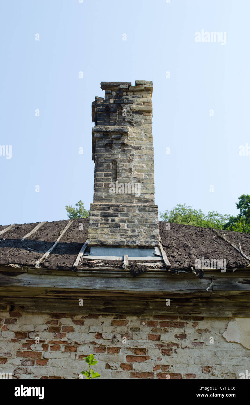 Ancient collapsing building wall roof and chimney on background of blue ...