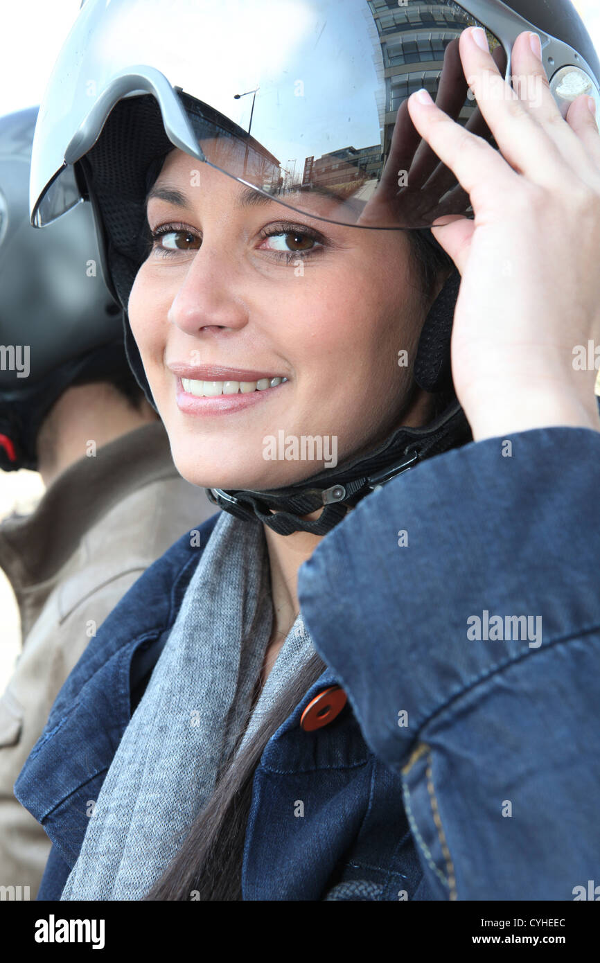 Woman putting helmet on Stock Photo - Alamy