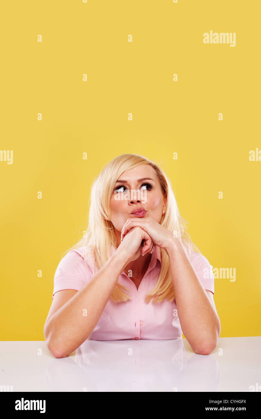 Happy smile from a pretty blonde girl leaning on one arm against a ...