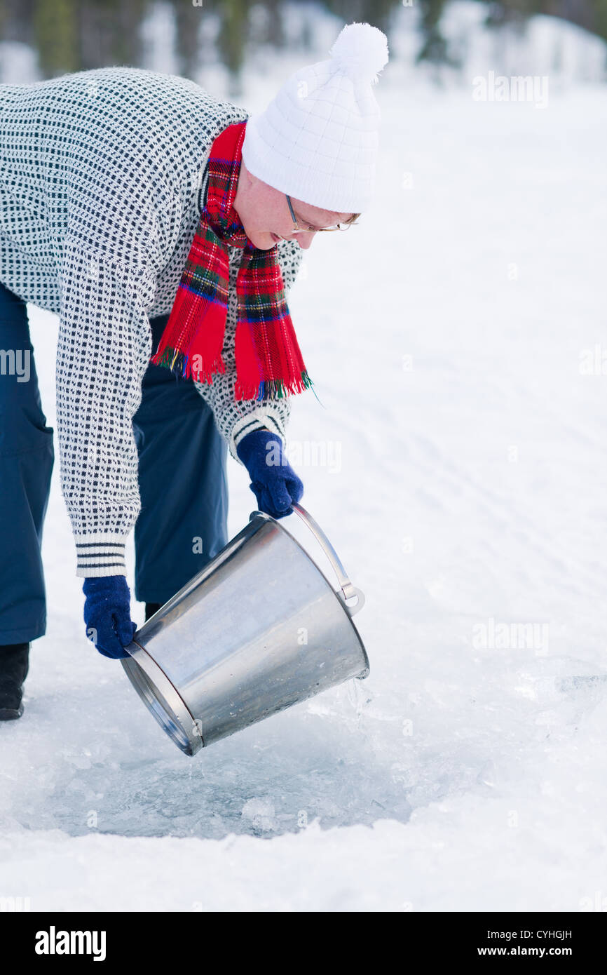 Woman take a loose ice out from a ice hole Stock Photo - Alamy