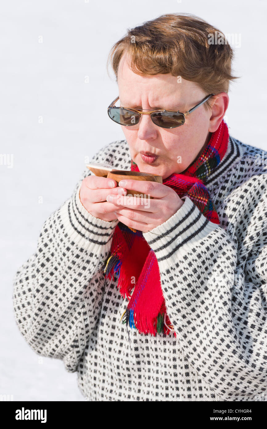 Woman drinking hot drink from a traditional finnish wooden cup Stock ...