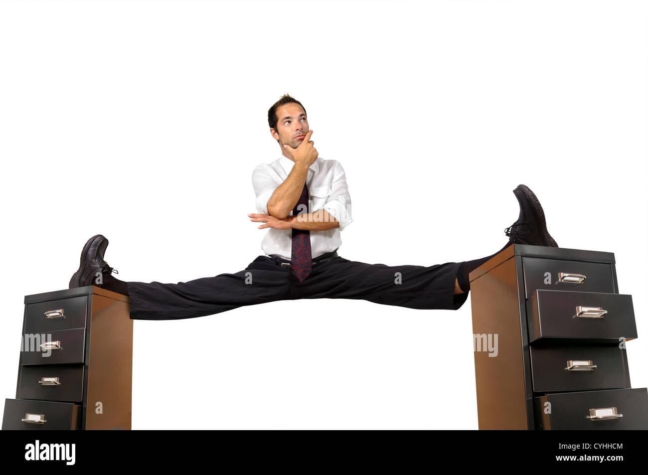 Businessman doing splits over cabinet files Stock Photo - Alamy