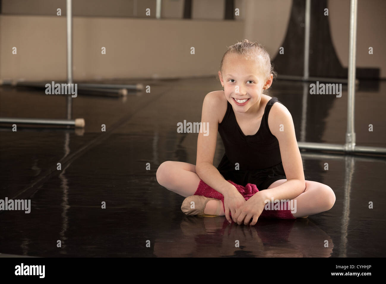 Cute young ballerina sitting on a dance floor Stock Photo - Alamy