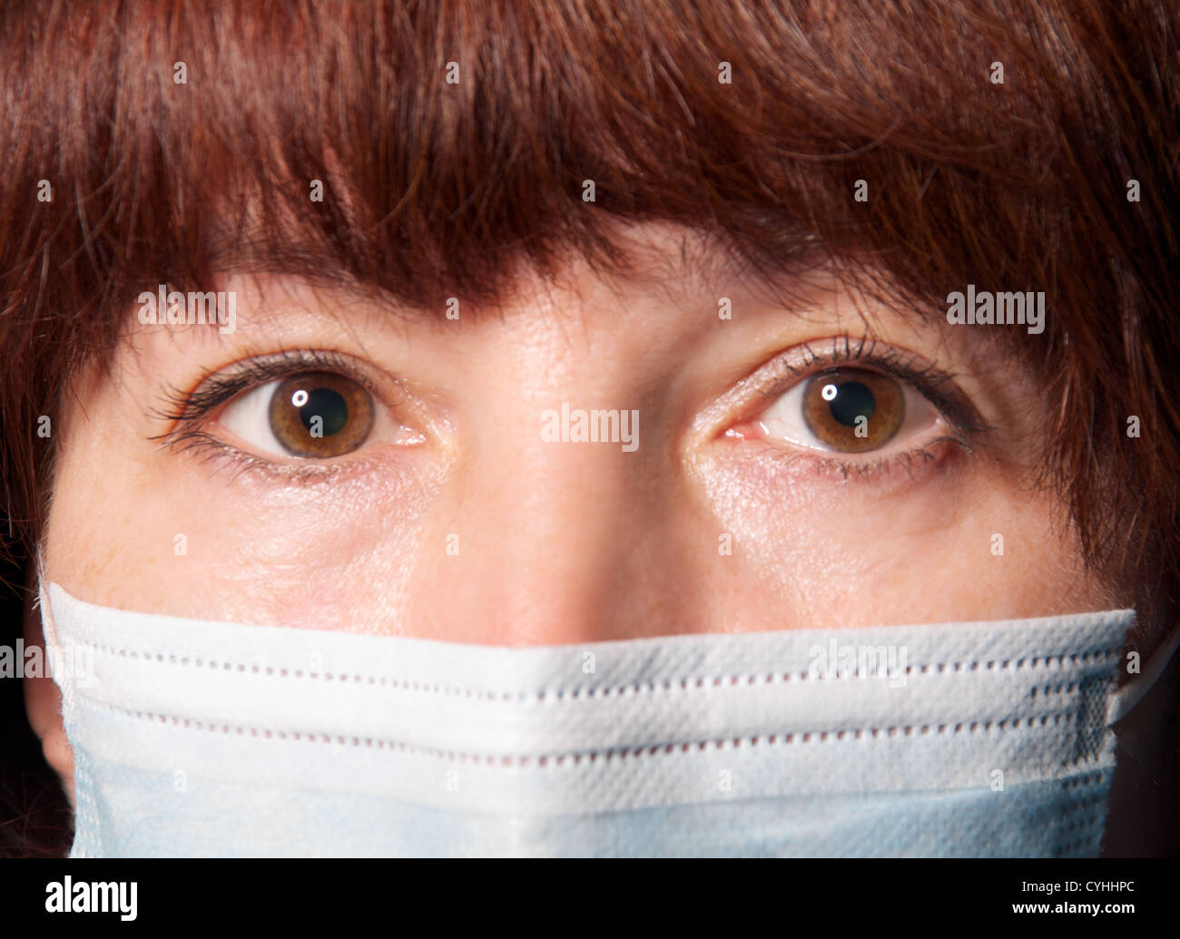scared woman in medical mask looks at camera Stock Photo - Alamy