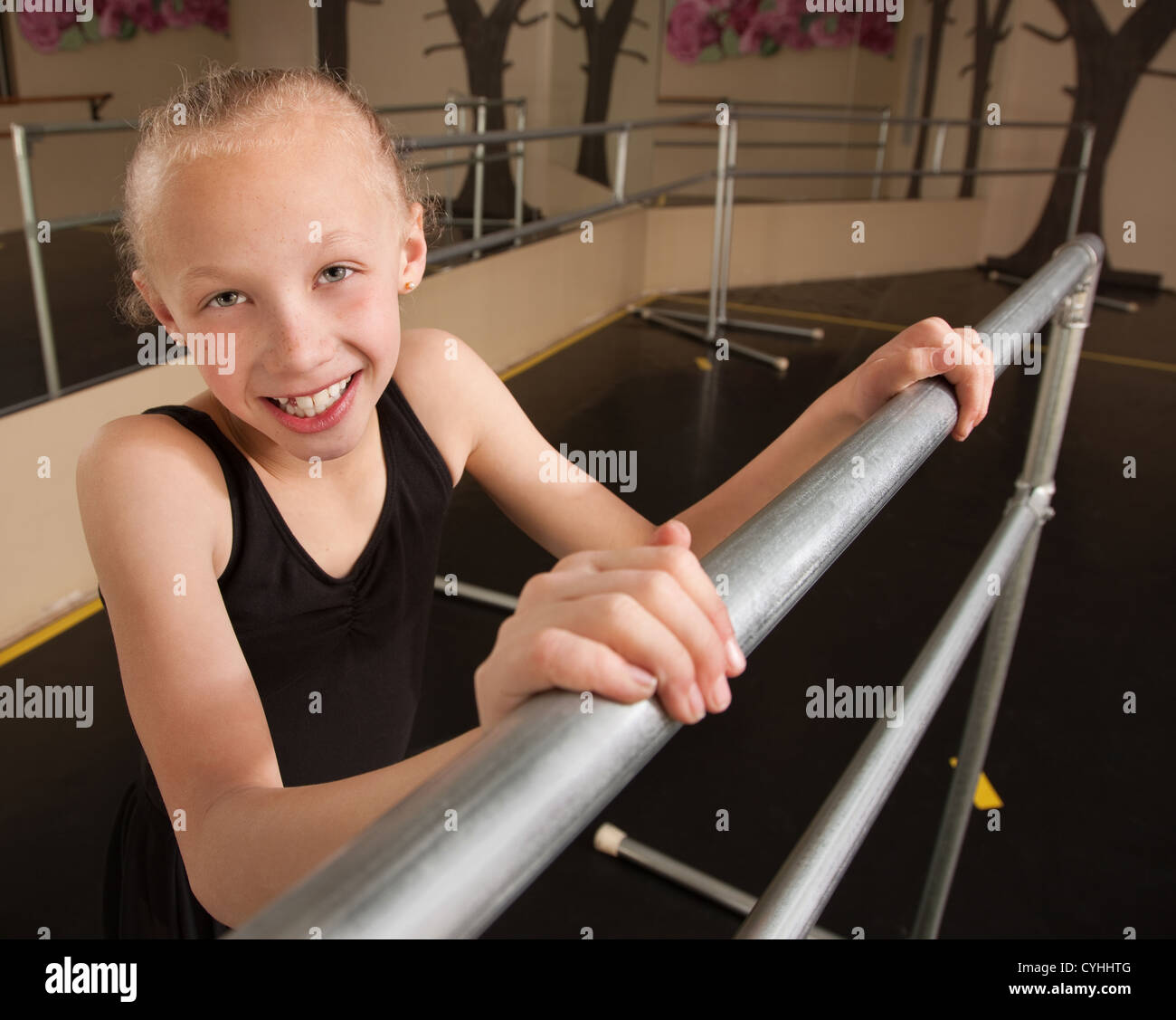 Young smiling ballet student holds railing in dance studio Stock Photo ...