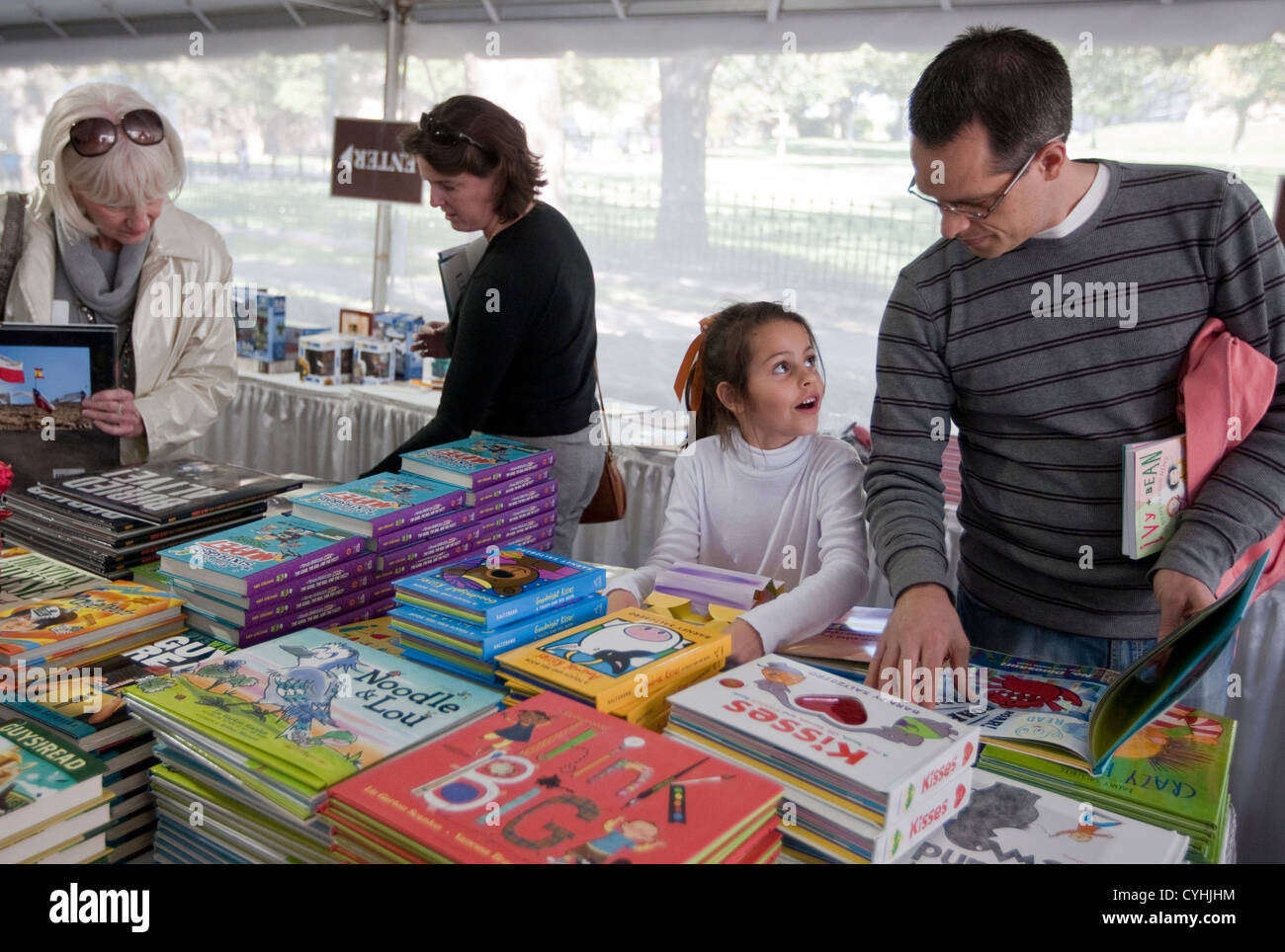 Father and daughter browse through stacks of children's books at the ...