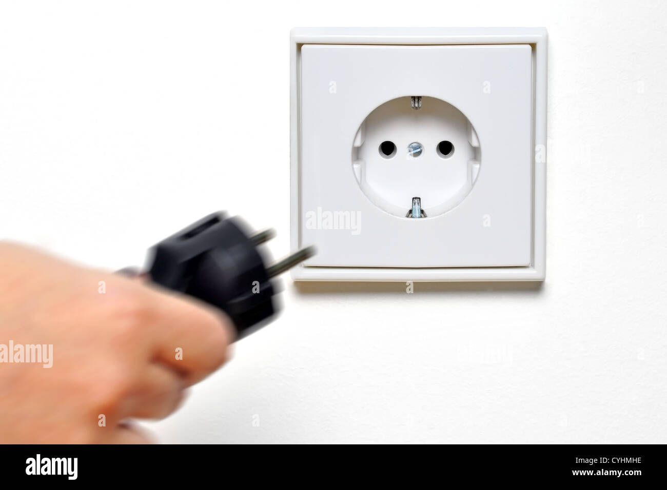 Hand connecting a plug to a socket Stock Photo - Alamy