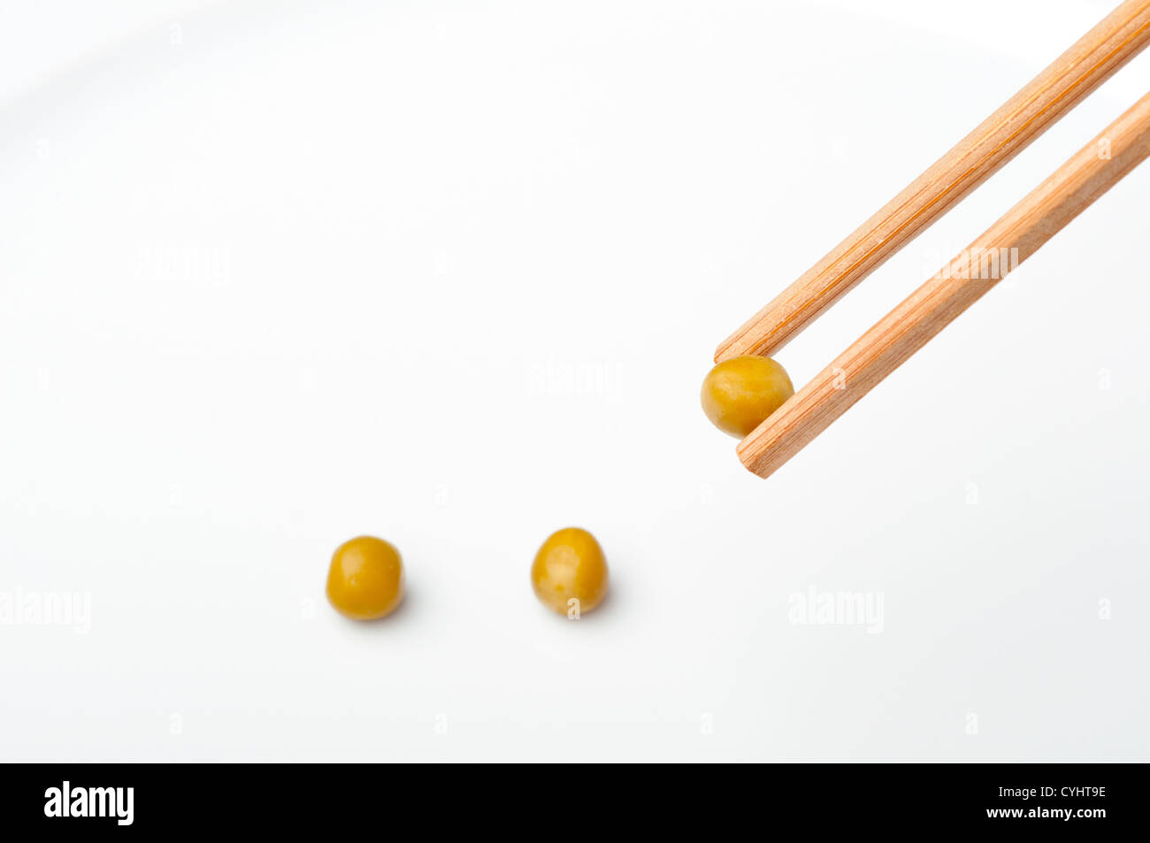 Three green peas and a pair of chop sticks Stock Photo - Alamy