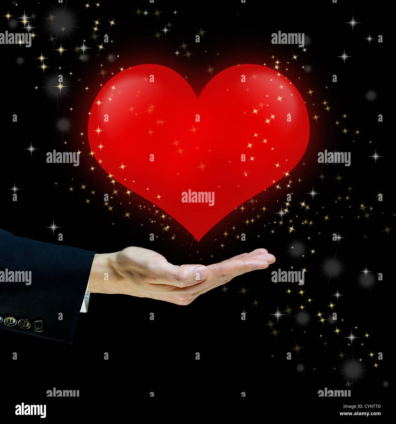 Red heart floating over a hand on black background with star dusts ...