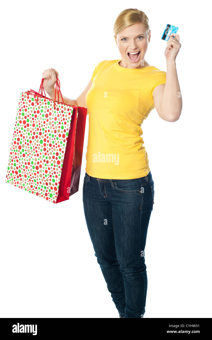Happy shopaholic girl showing credit card, carrying paper bag Stock ...
