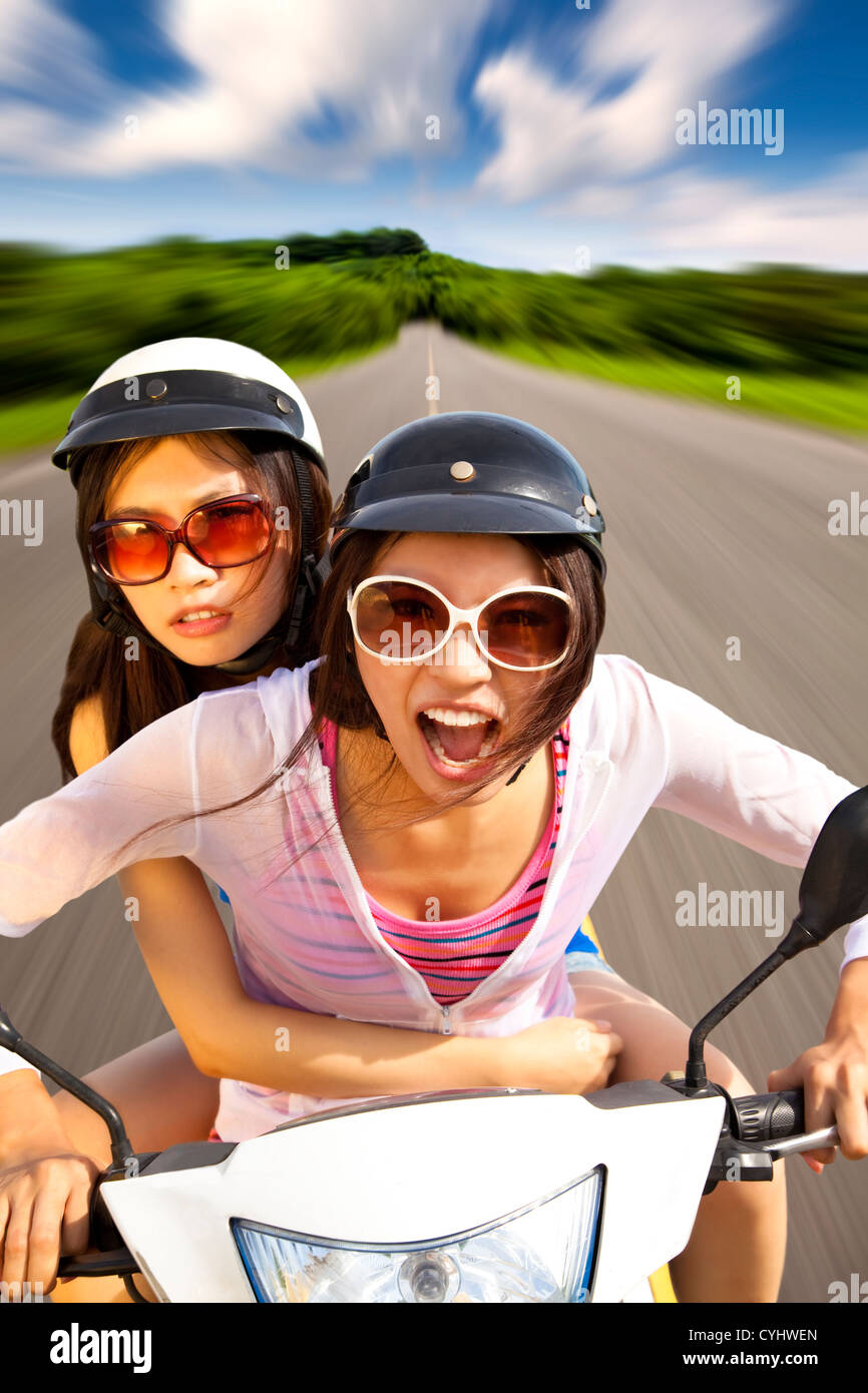two girls riding scooter on the road Stock Photo - Alamy