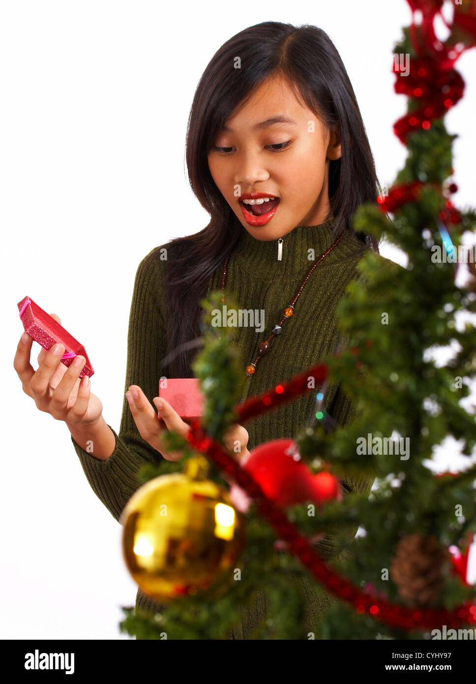 Girl Behind A Christmas Tree Excited By Her Beautiful Gift Stock Photo ...