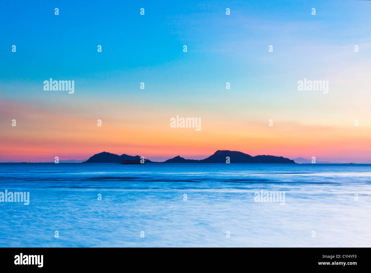 Island at sunset over the ocean Stock Photo - Alamy