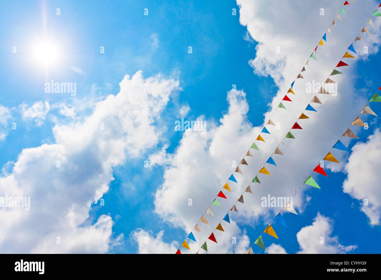 Blue sky with multi colored party flags hanging Stock Photo - Alamy