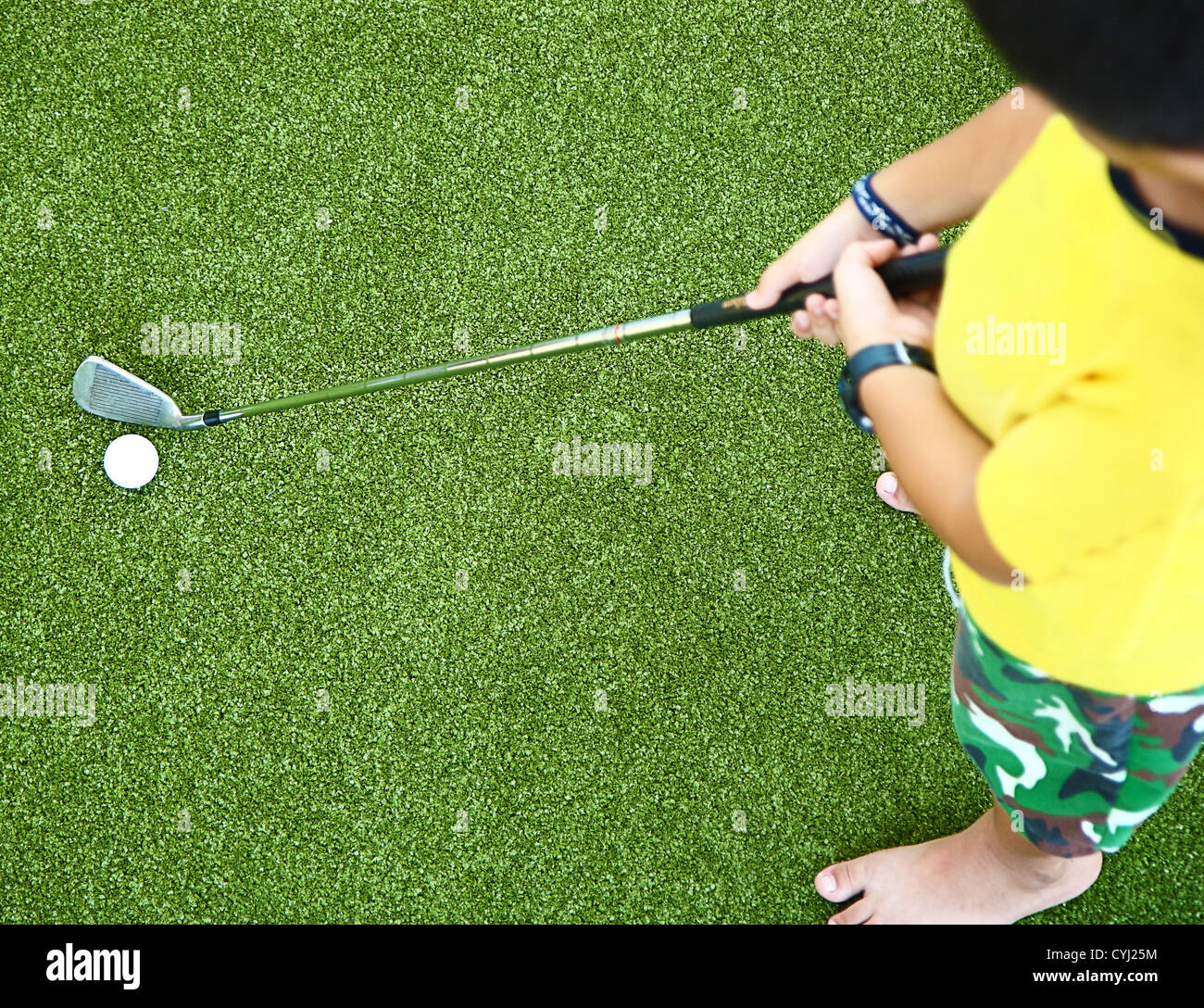 Small Kid Outside On The Grass Learning To Play Golf Stock Photo - Alamy