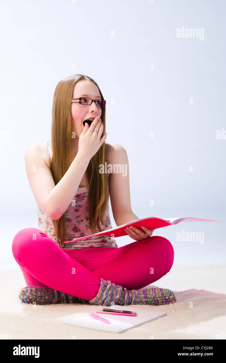 A young beautiful girl student yawning in the middle of study Stock ...