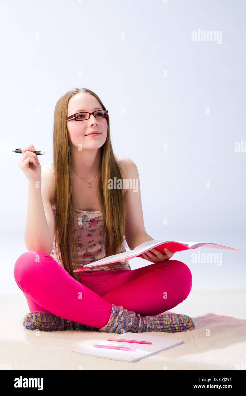 A young beautiful girl student pondering in the middle of study Stock ...