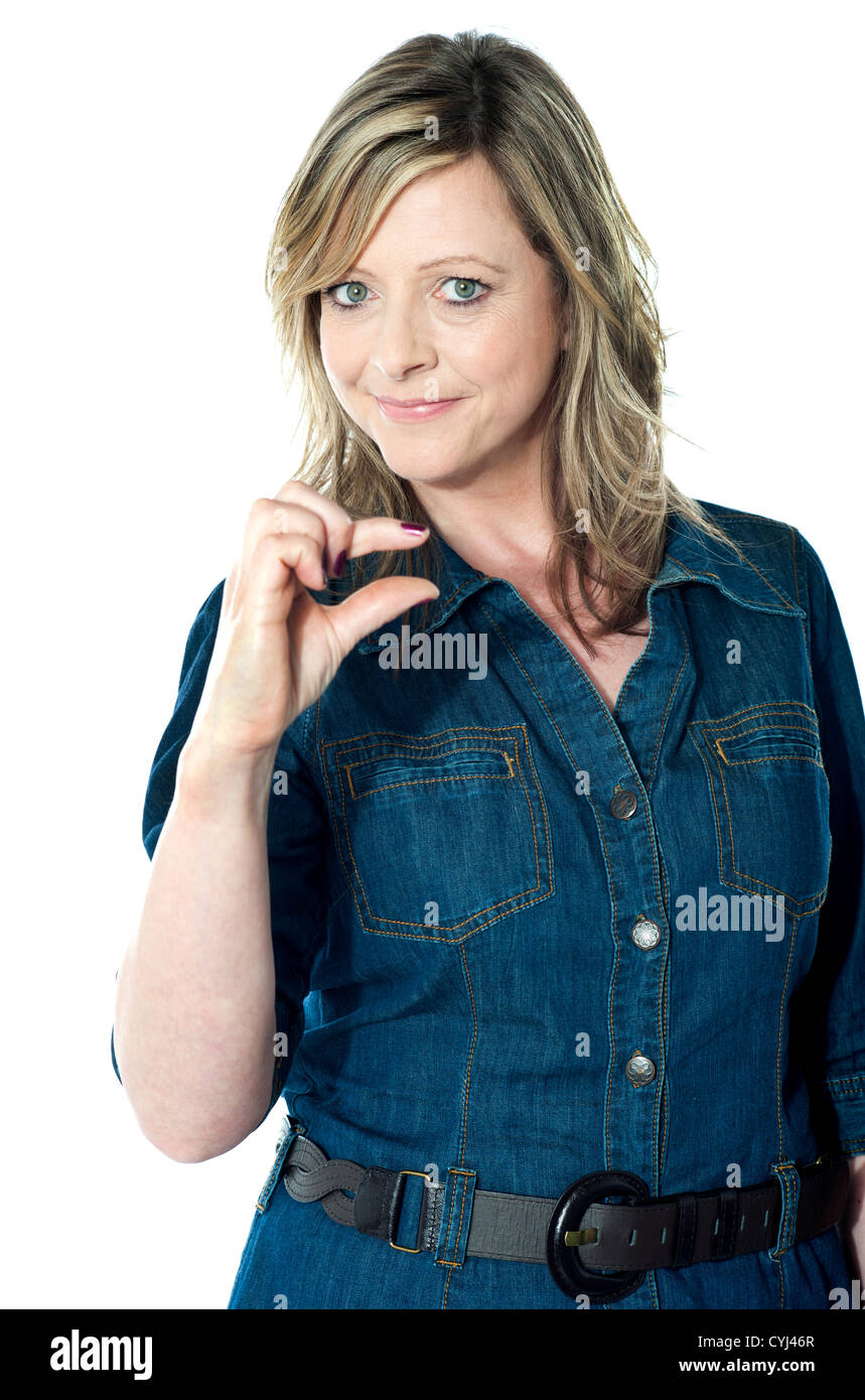 Female indicating little bit gesture against white background Stock ...