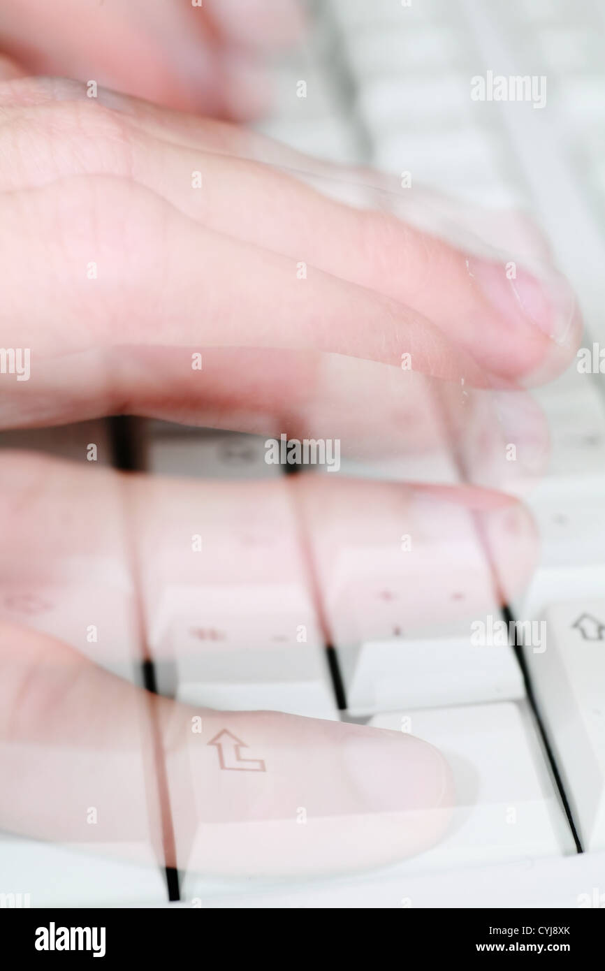Hand typing fast on a keyboard with a lot of motionblur Stock Photo - Alamy