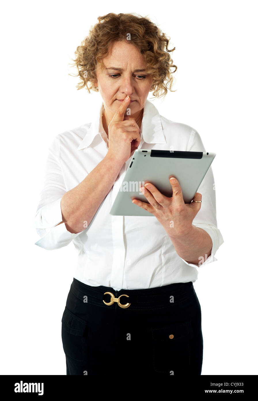 Businesswoman looking at tablet and thinking deep. Lost in thoughts ...