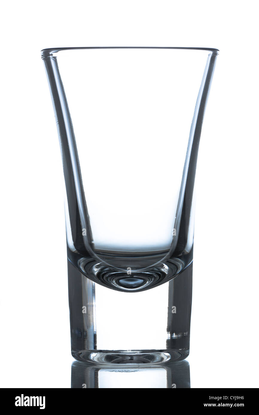 An empty shot glass on a refelctive surface. Isolated on white Stock ...