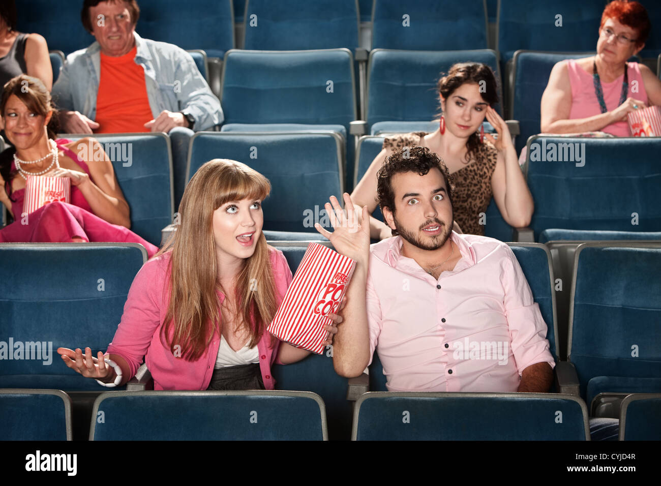 Annoyed audience and arguing couple in movie theater Stock Photo - Alamy