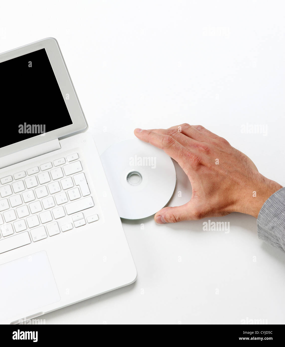 Businessman inserting a cd on white laptop - top view Stock Photo - Alamy