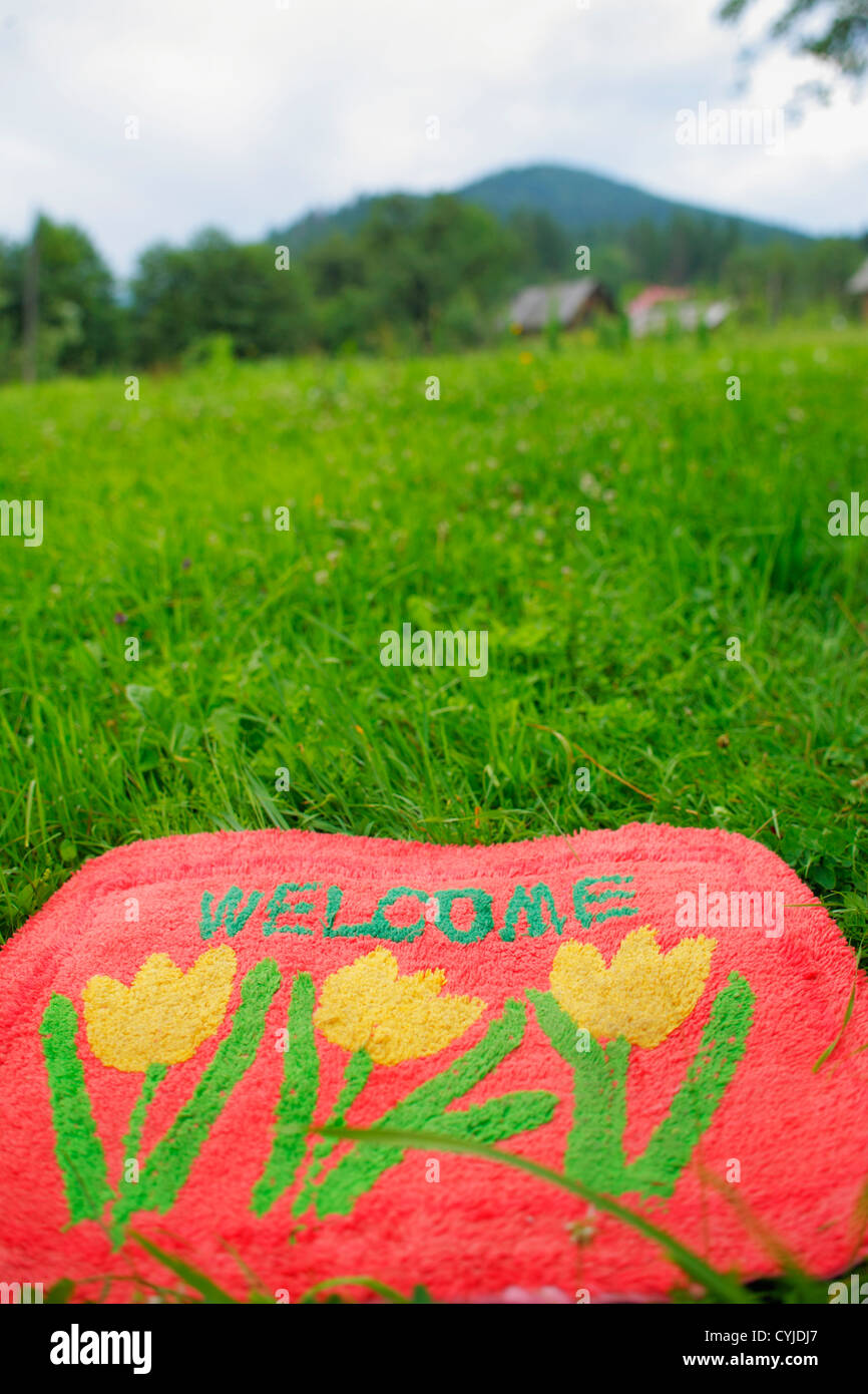 Photo of a welcome mat in front of a green meadow Stock Photo - Alamy