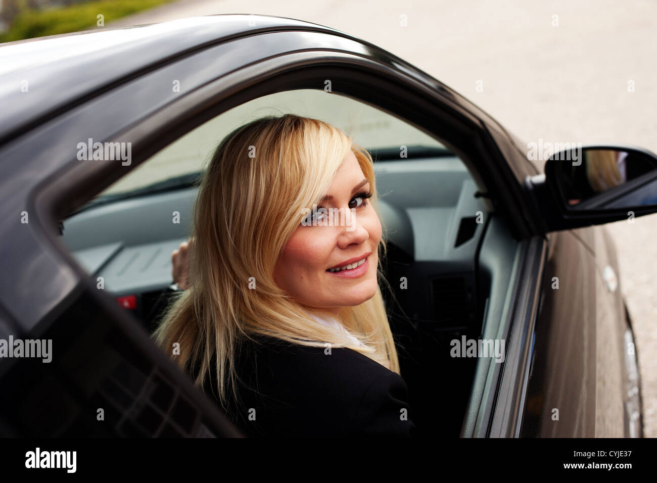 gorgeous blonde looking behind her back while driving Stock Photo - Alamy
