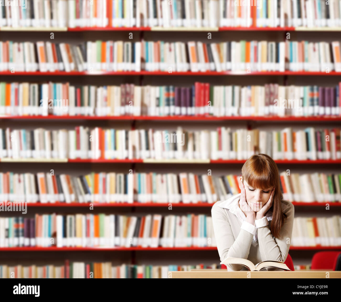Portrait of a serious young student reading a book in a library Stock ...