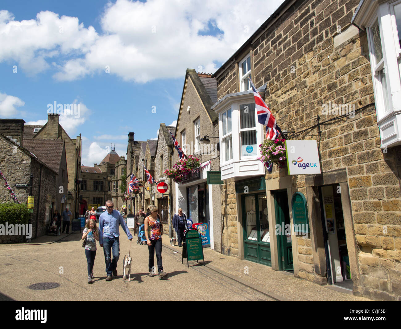 people shopping and walking around the Derbyshire village of Bakewell ...