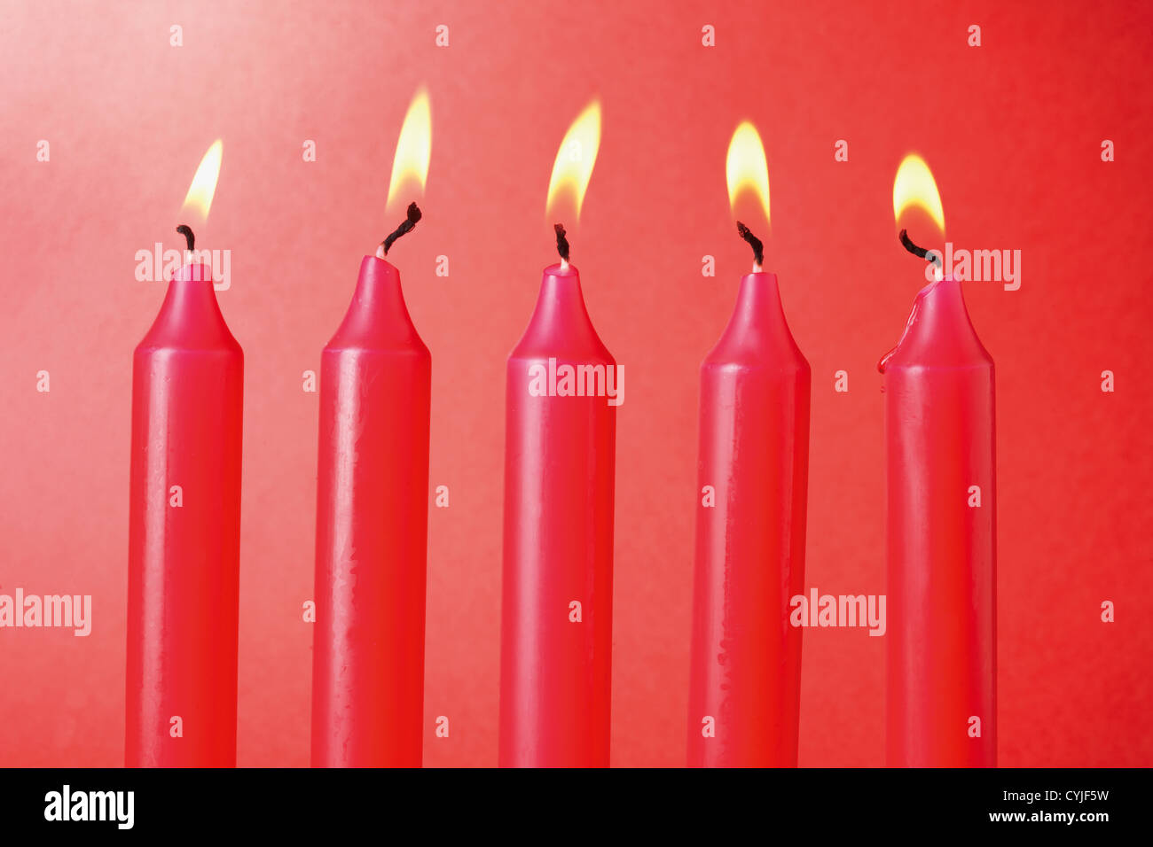 Five Red Candles on red background Stock Photo - Alamy