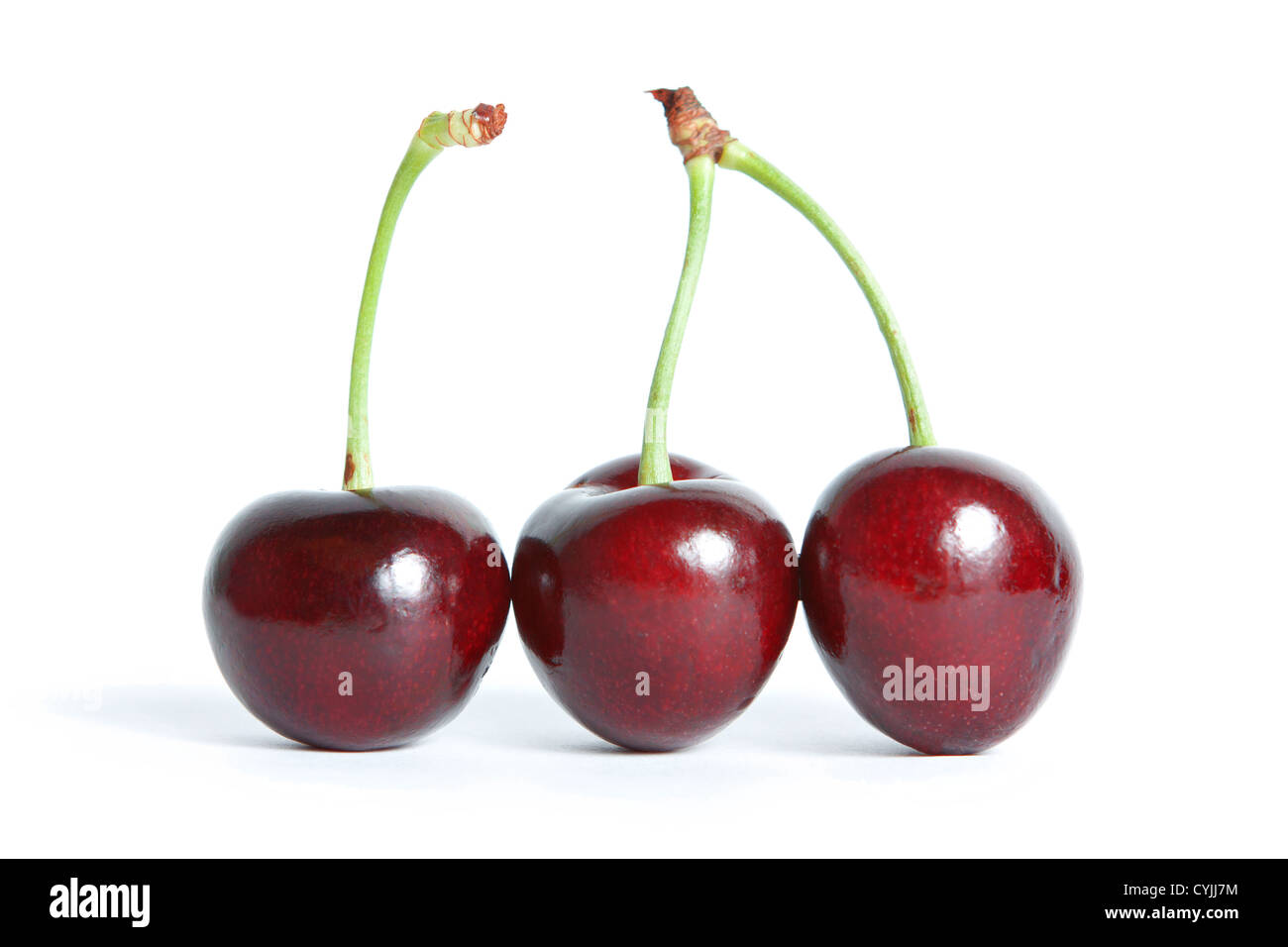 three red cherry isolated on a white background Stock Photo - Alamy