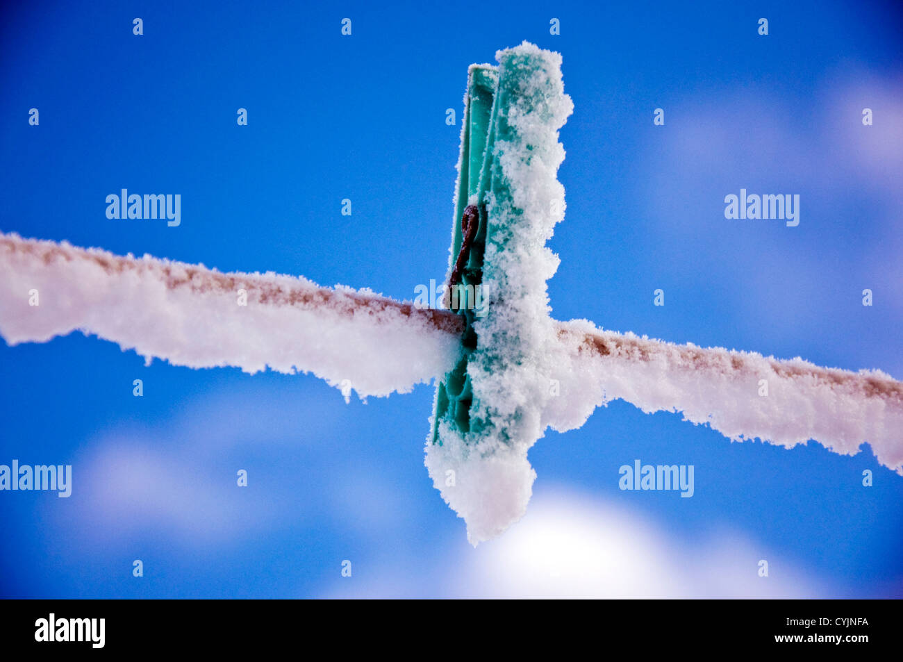 Snow on frozen peg on washing line Stock Photo - Alamy
