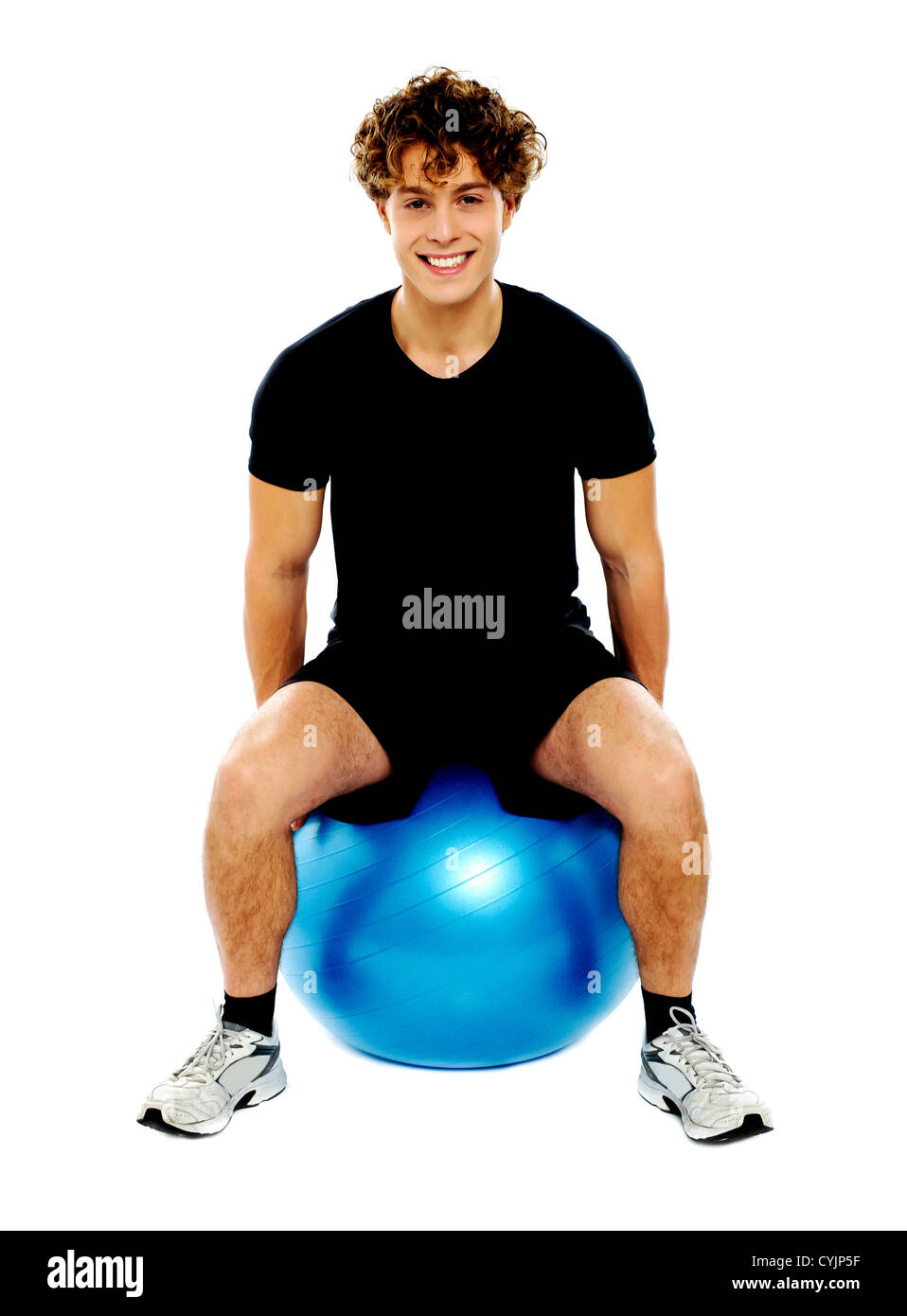 Handsome guy seated on exercise ball over white background Stock Photo ...