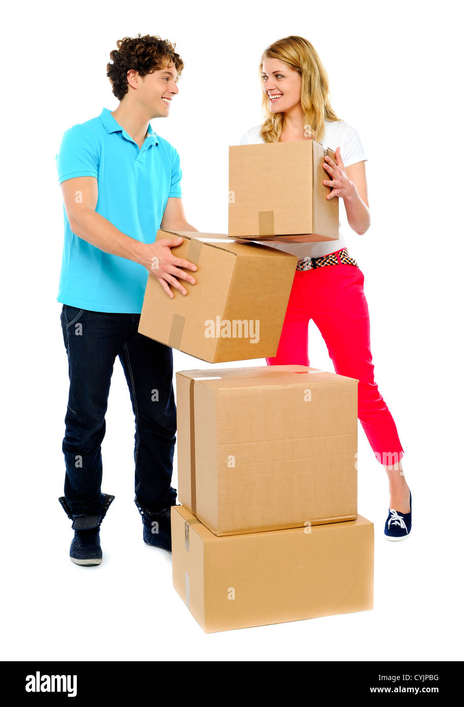 Happy young couple moving cardboard boxes smiling with eye contact ...