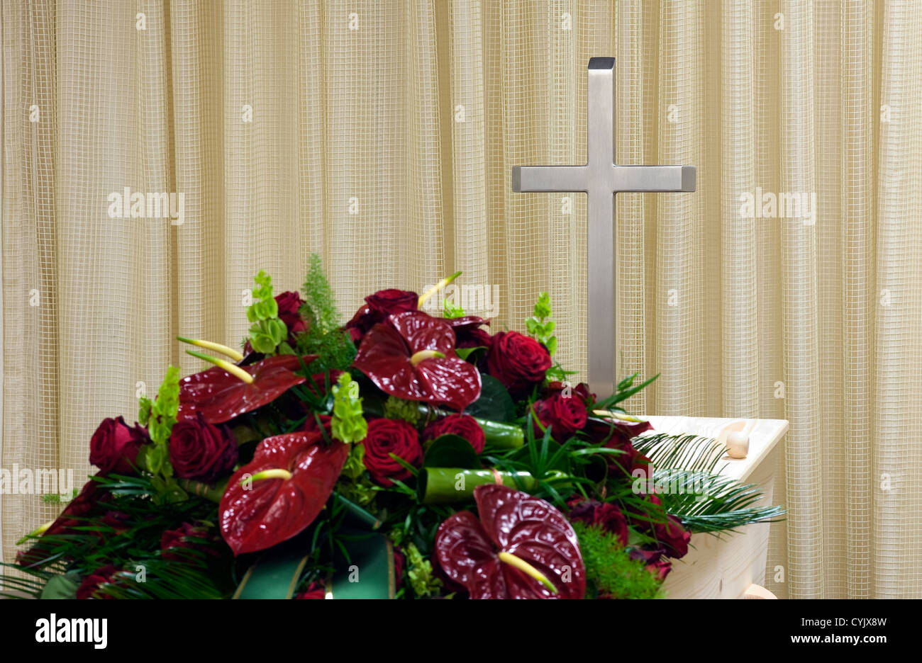 A coffin with cross in a morgue with a flower arrangement Stock Photo ...