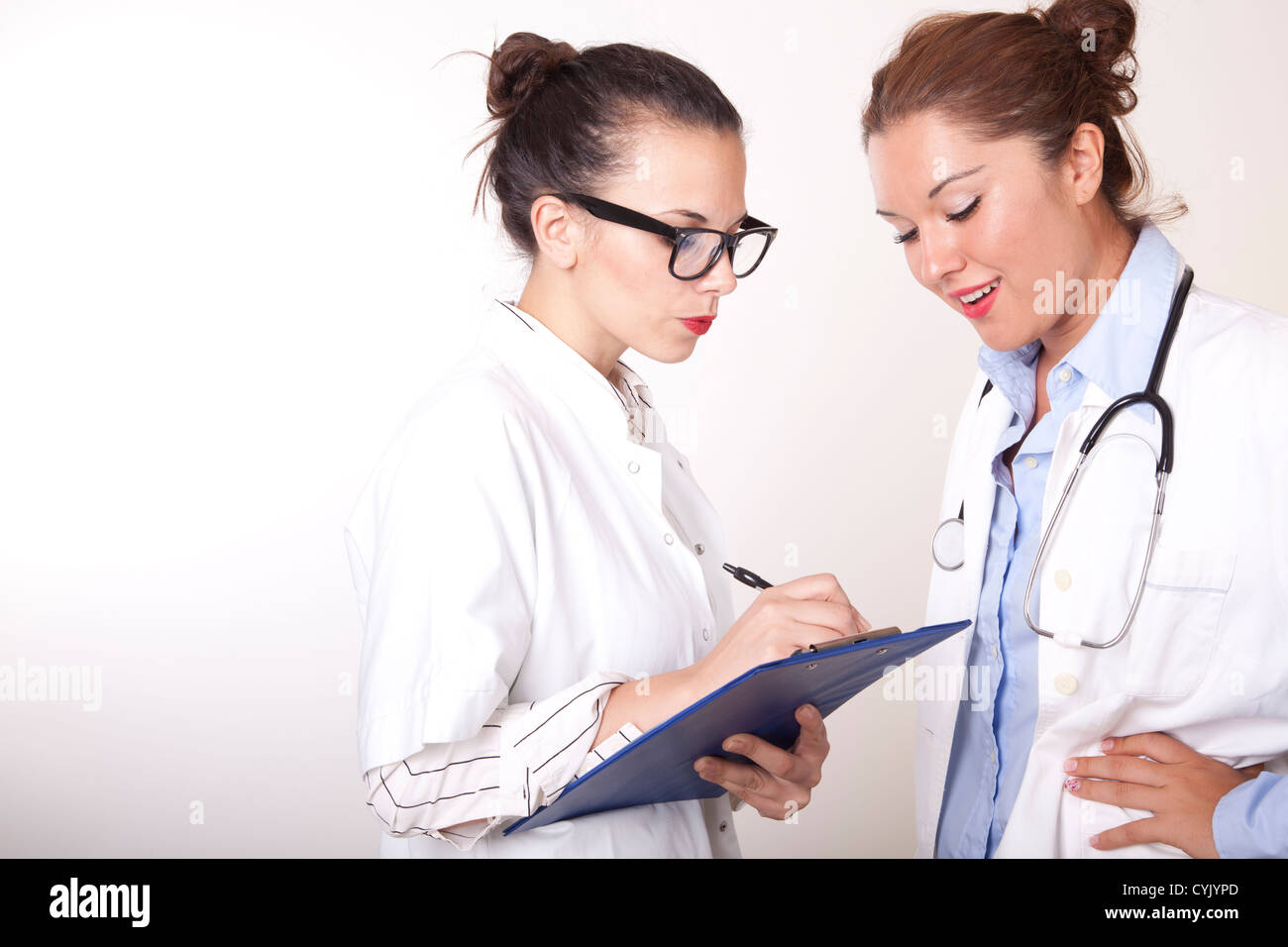 Portrait of a two young beautiful female doctors working Stock Photo ...