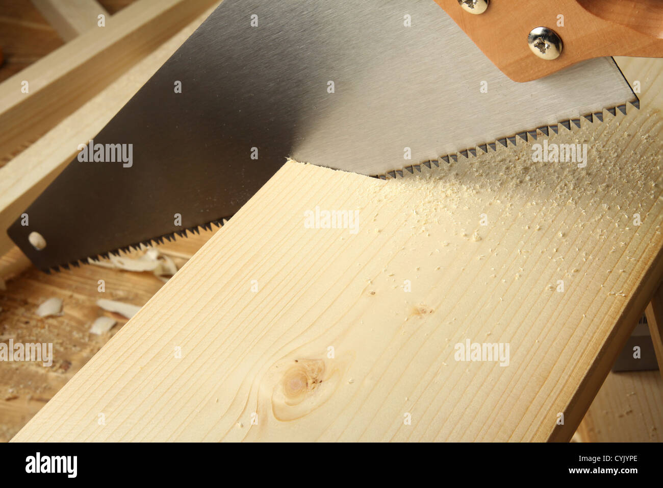 Wood workshop. Hand saw cutting plank Stock Photo - Alamy