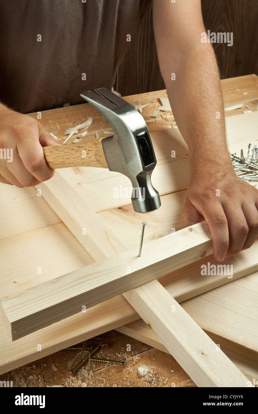 Wood workshop. Carpenter hammering a nail Stock Photo - Alamy
