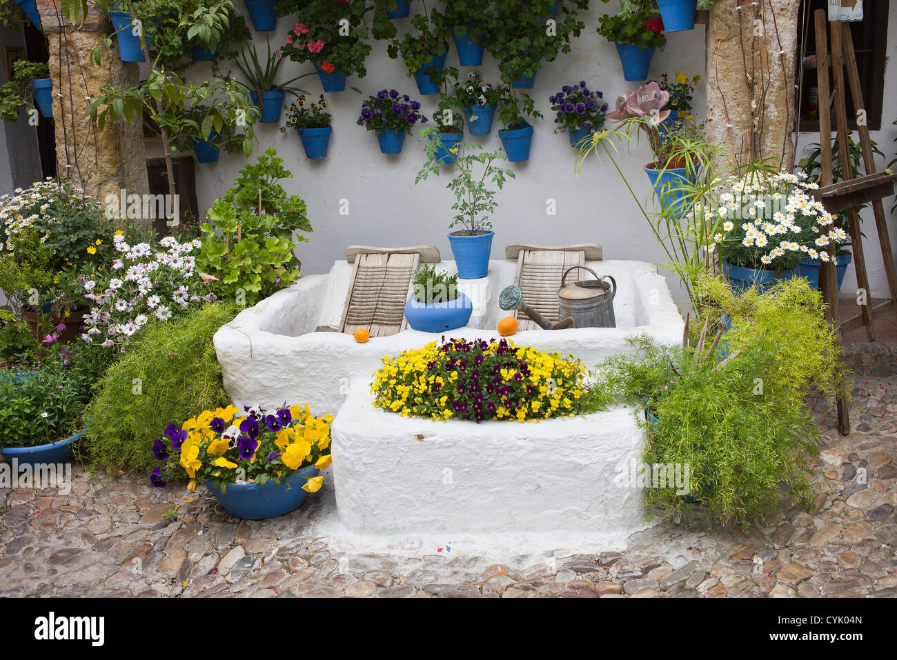 Traditional Andalusian courtyard full of plants and flowers and place ...