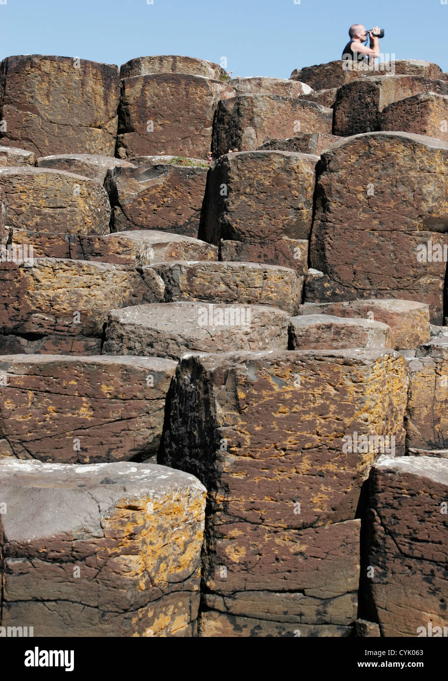 A woman is watching out from the polygonal columns of layered basalt at ...