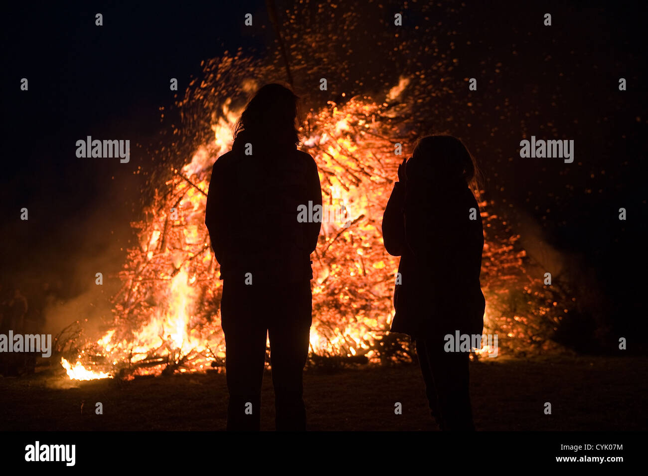 Two girls are watching a huge bonfire, a tradition with easter in North ...