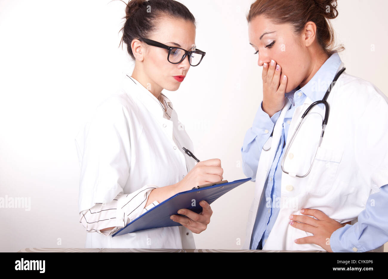 Portrait of a two young beautiful female doctors working Stock Photo ...